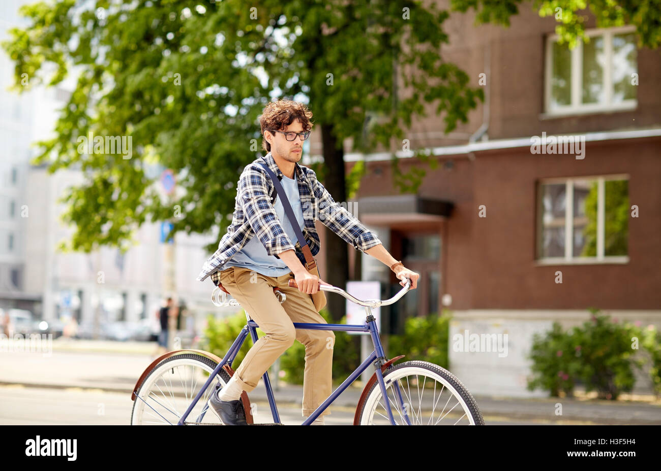 young hipster man with bag riding fixed gear bike Stock Photo - Alamy