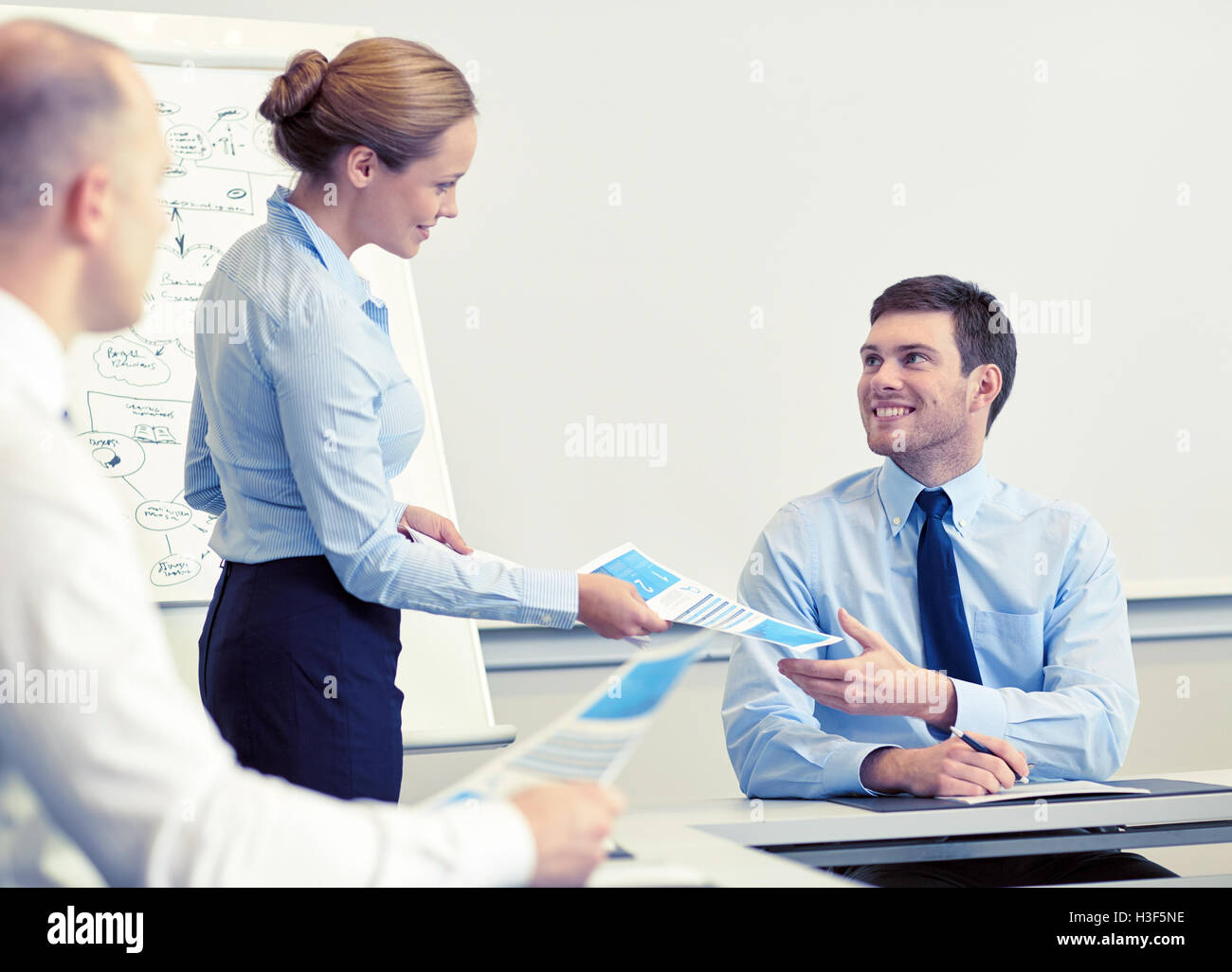 smiling woman giving papers to man in office Stock Photo - Alamy