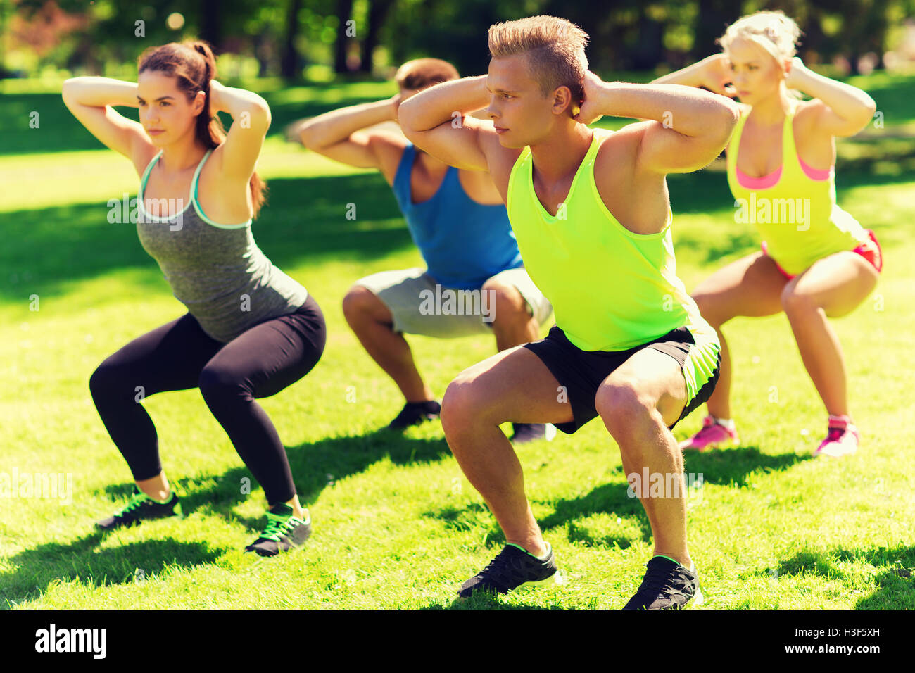 group of friends or sportsmen exercising outdoors Stock Photo - Alamy