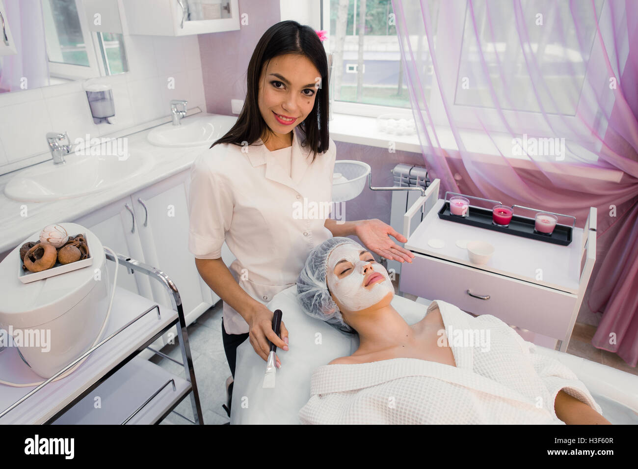 Portrait of young woman while facial cosmetic procedure in spa salon ...