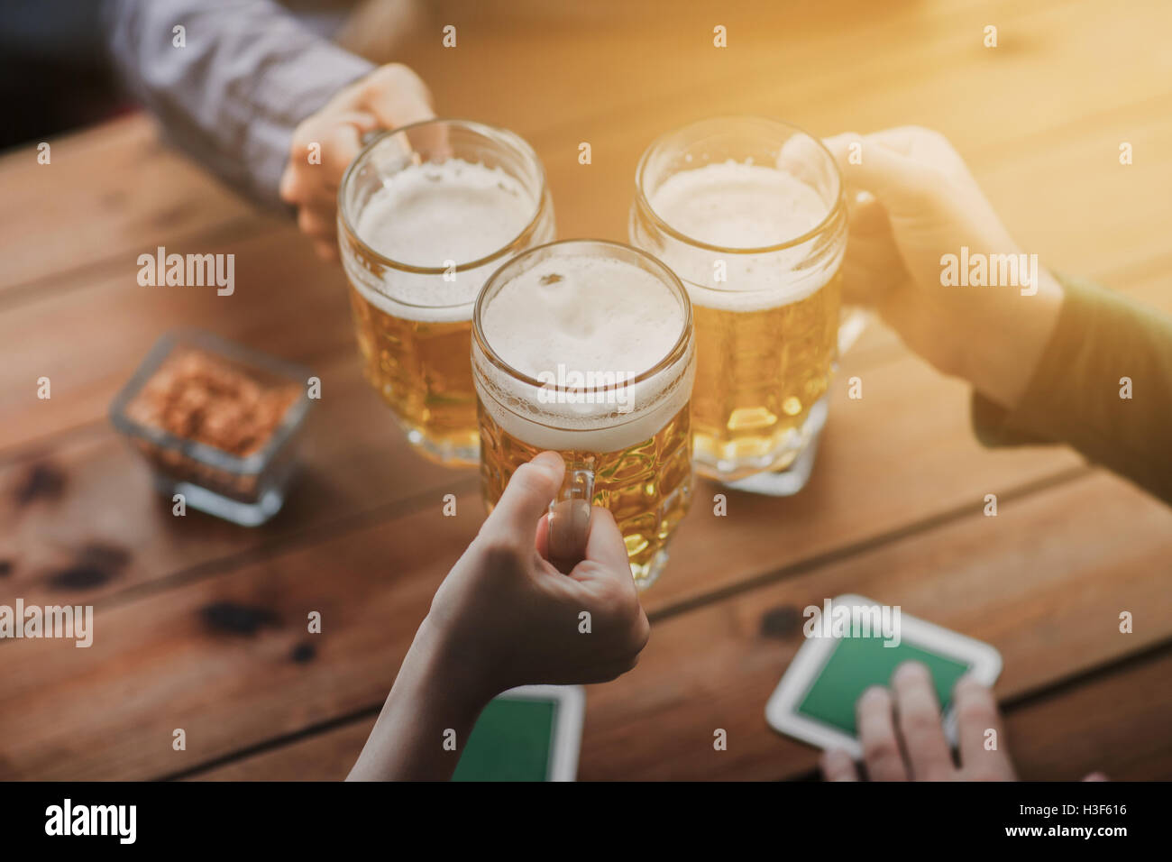 close up of hands with beer mugs at bar or pub Stock Photo - Alamy
