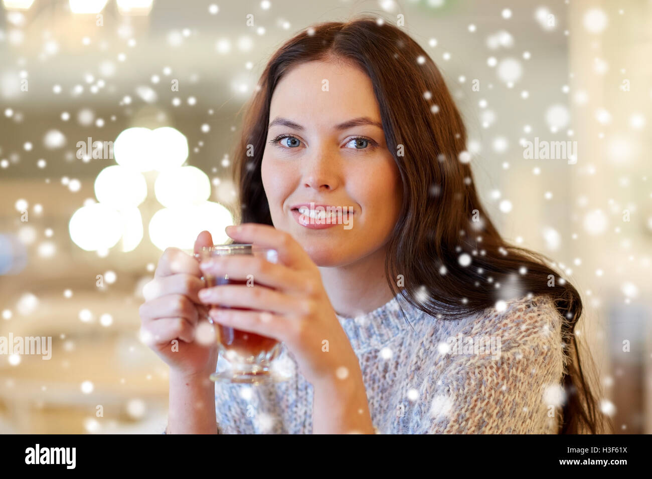 smiling young woman drinking tea at cafe Stock Photo - Alamy