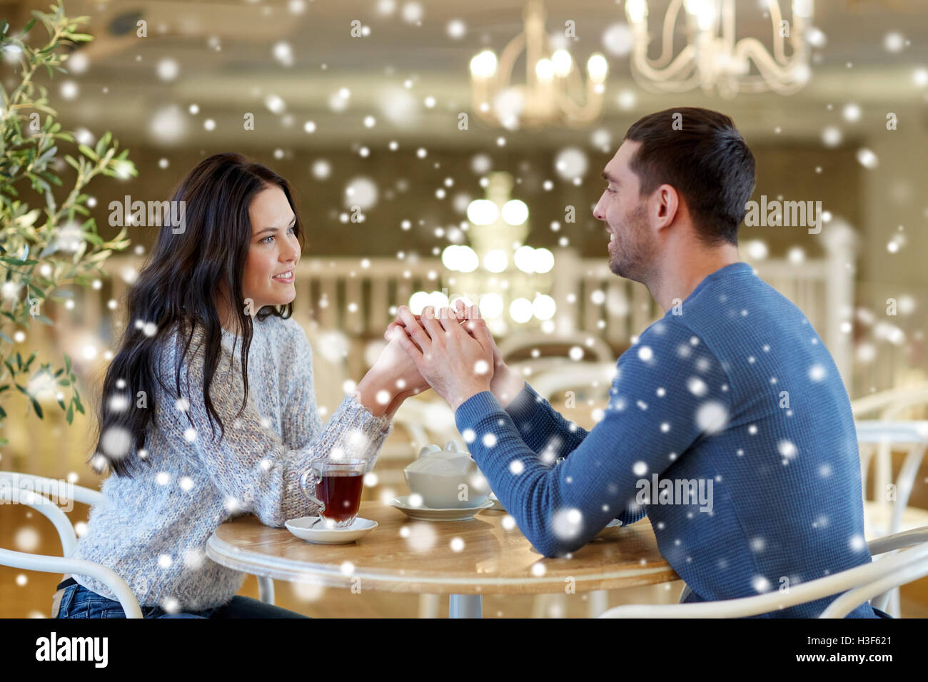 happy couple with tea holding hands at restaurant Stock Photo - Alamy