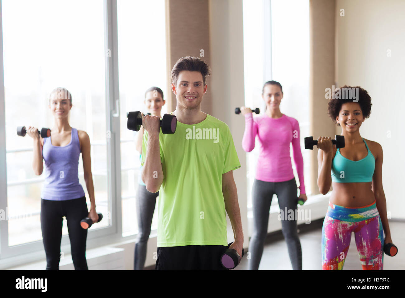 group of smiling people working out with dumbbells Stock Photo - Alamy