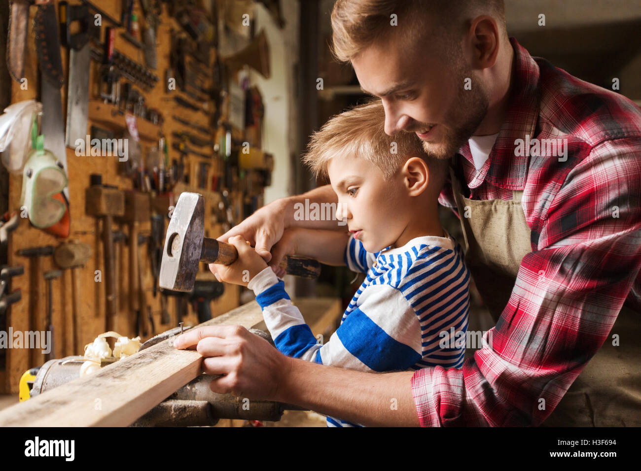 father and son with hammer working at workshop Stock Photo - Alamy
