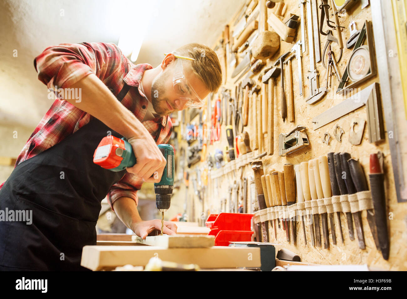 carpenter with drill drilling plank at workshop Stock Photo - Alamy