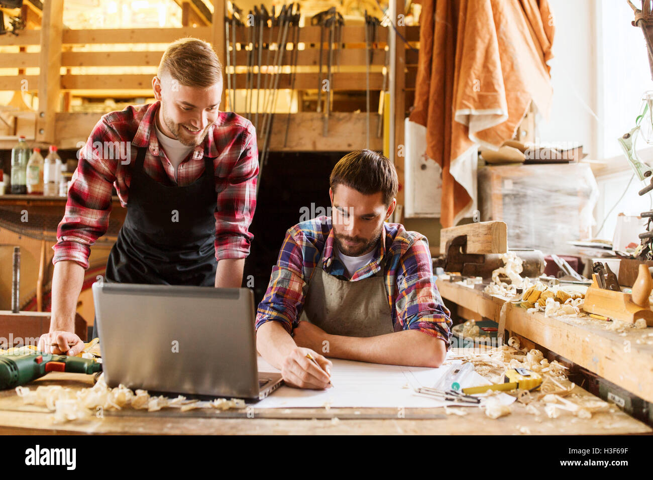 carpenters with laptop and blueprint at workshop Stock Photo - Alamy