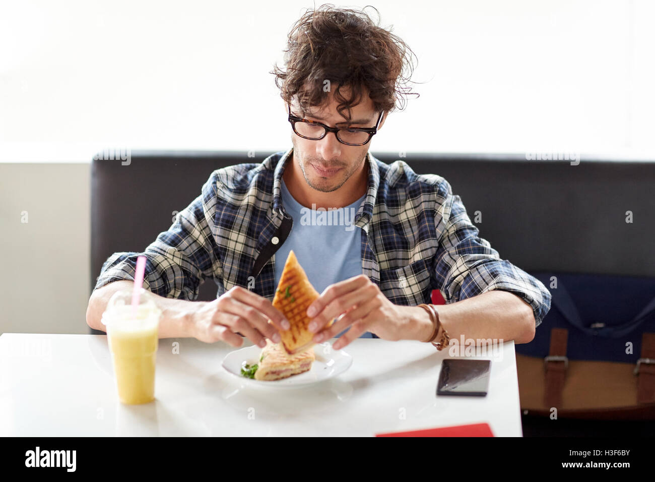 happy man eating sandwich at cafe for lunch Stock Photo - Alamy