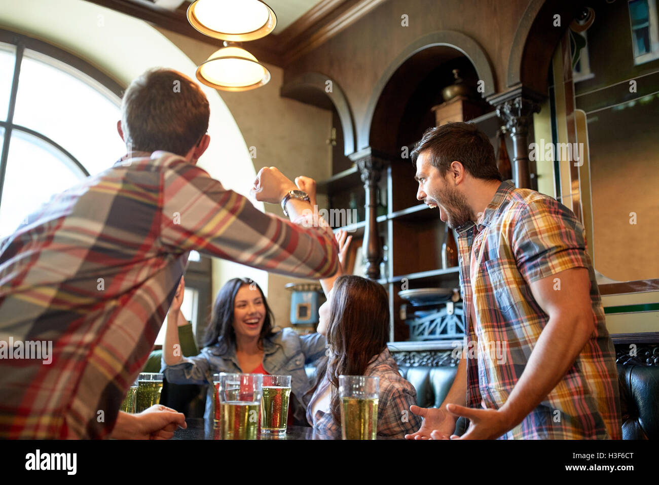 happy friends with beer celebrating at bar or pub Stock Photo - Alamy