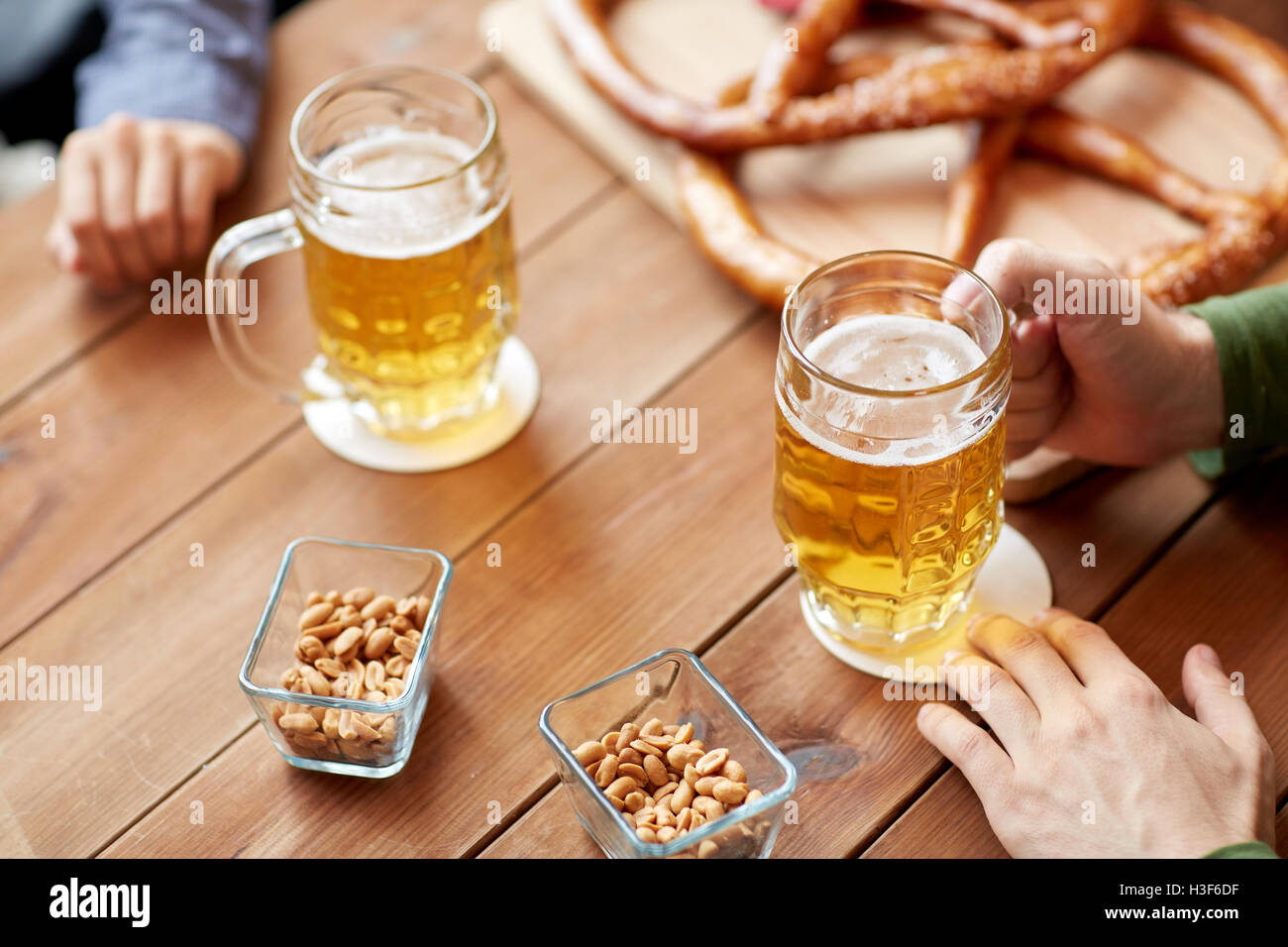 close up of hands with beer mugs at bar or pub Stock Photo - Alamy