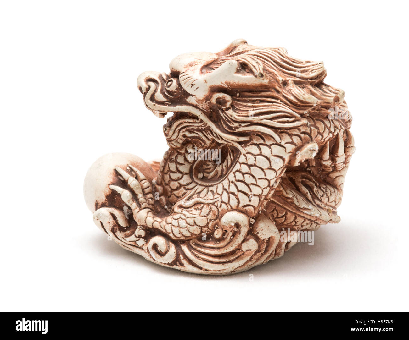 Netsuke of east dragon, which guarding the egg. A miniature sculpture ...