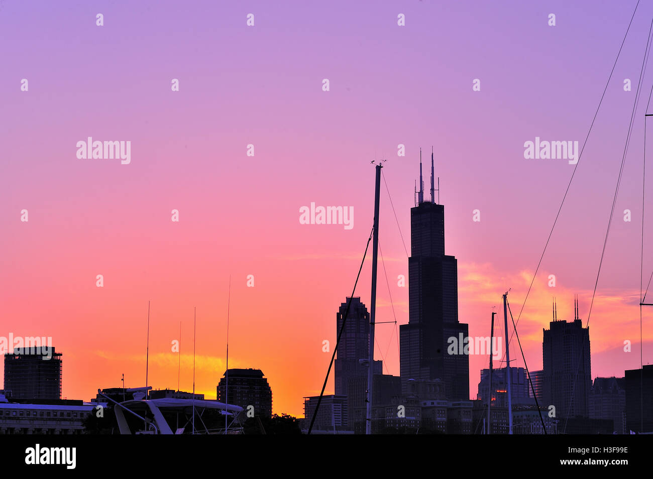Chicago, Illinois, USA. The setting sun creates a multi-hued glow in ...