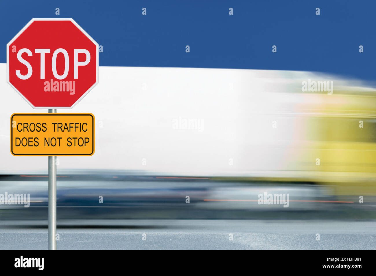 Red stop road sign, motion blurred truck vehicle traffic in background ...