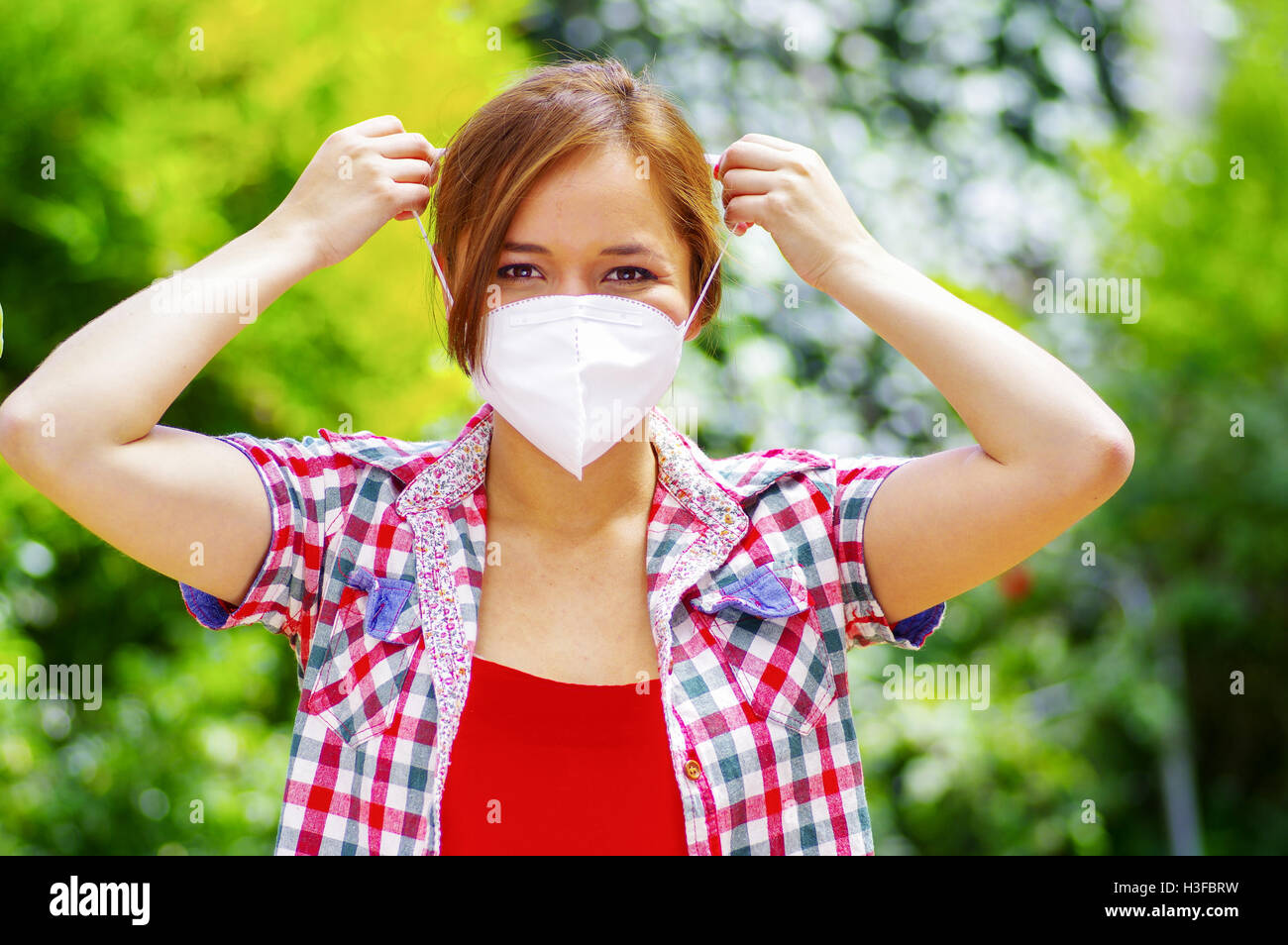 woman with colorfull clothes putting on a work mask Stock Photo - Alamy