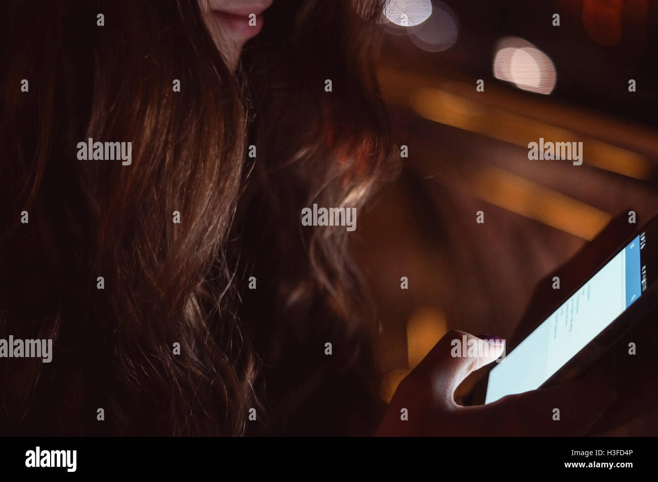 Girl using smart phone at night in front of blurred city lights Stock ...