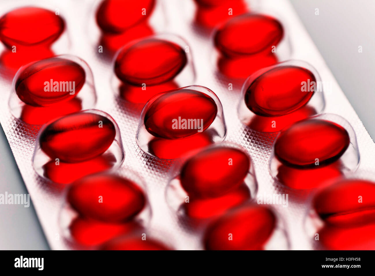 Many red oil pills inside of foil packaging Stock Photo - Alamy