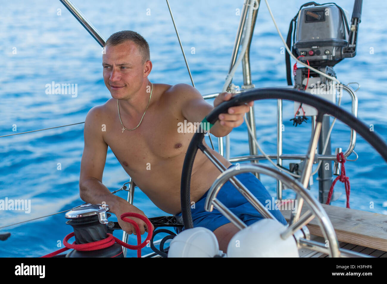 Man skipper relaxed runs his sailing yaht boat Stock Photo - Alamy