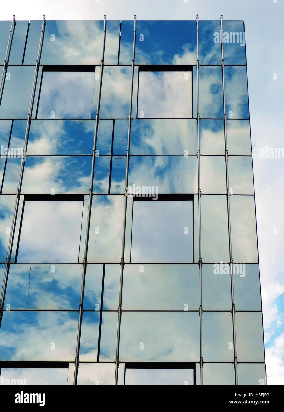 Detail of glass facade of modern office building with reflection of ...