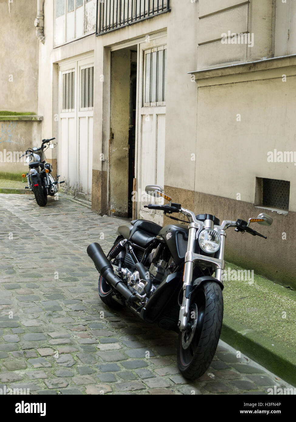 Two powerful motorbikes (Harley Davidson in foreground) parked in Paris ...