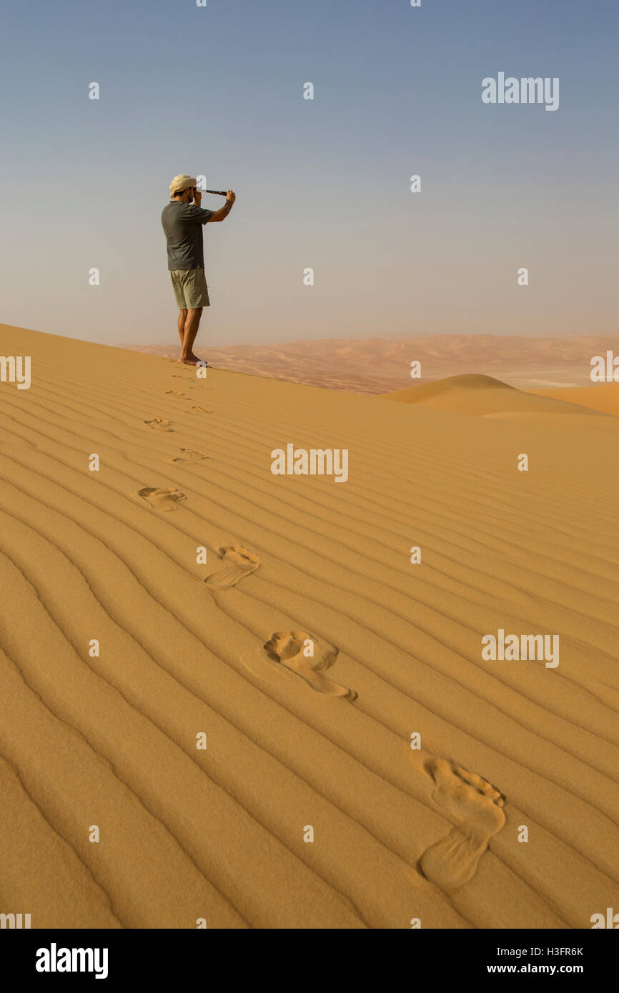 Man looking through spyglass in a desert Stock Photo - Alamy
