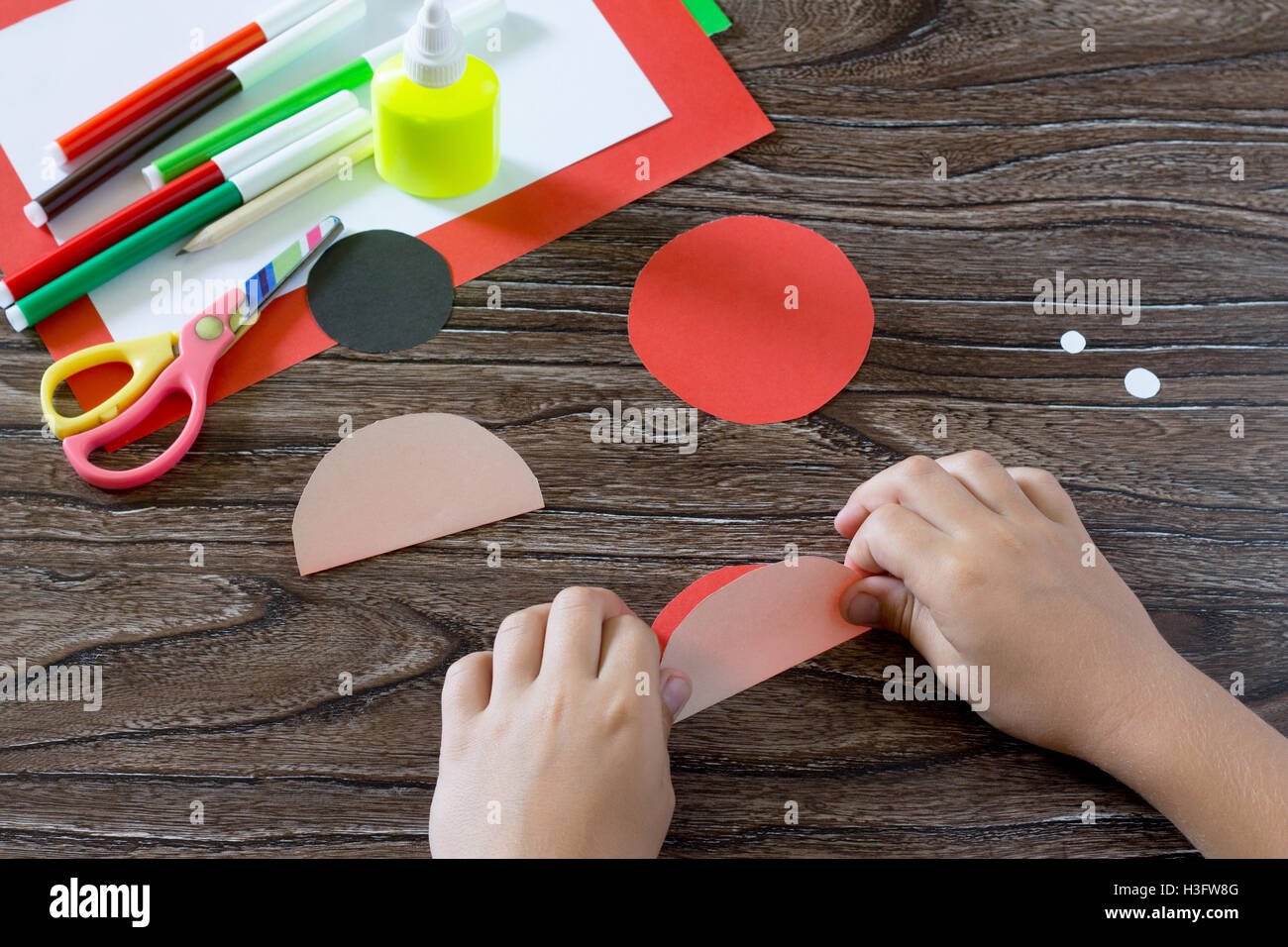 The child holds a sheet of paper and fold it in half. The child makes a ...