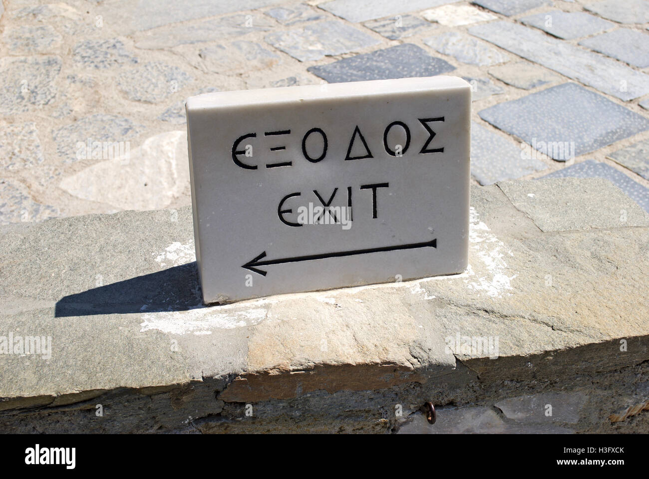 Greek exit (exodos) sign with arrow pointing left Stock Photo - Alamy