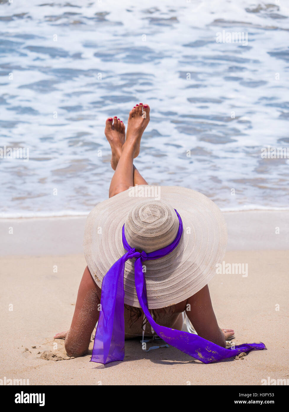 Young woman wearing bikini lying on sand hi-res stock photography and ...