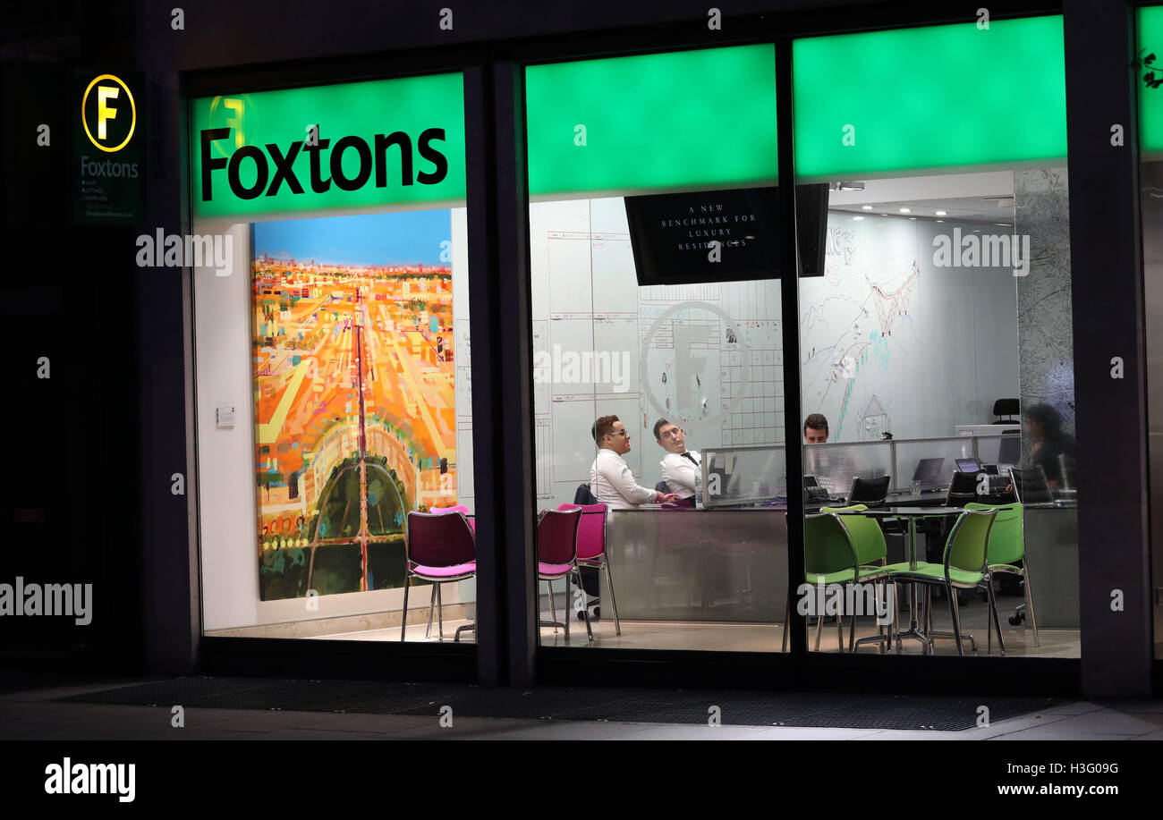 Foxtons estate agents working night window late Stock Photo - Alamy