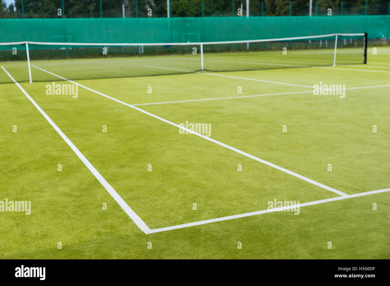 New and empty lawn tennis court and net outdoor in summer or spring ...
