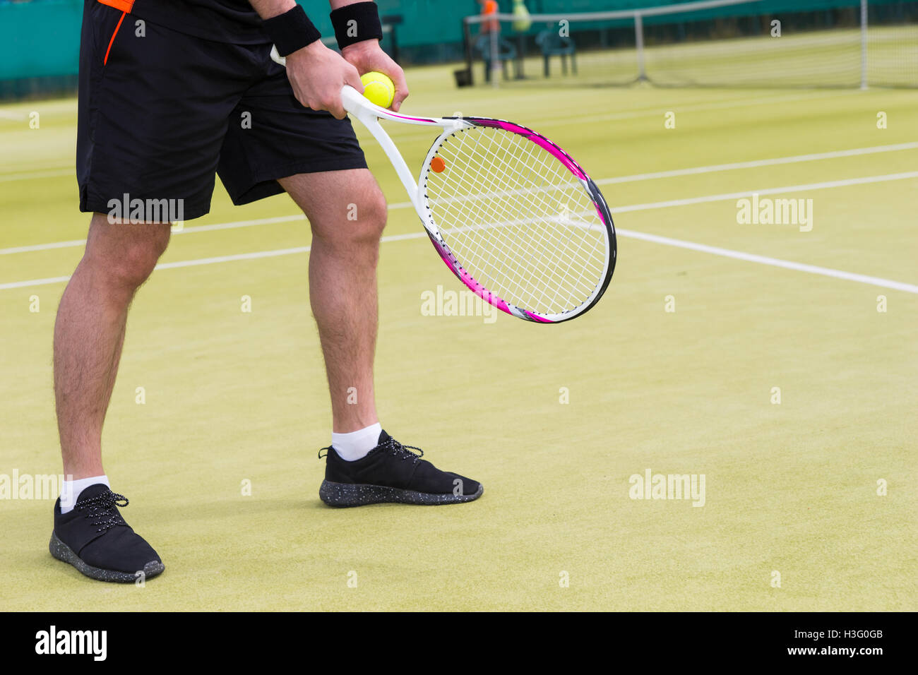 Close up male player's hand with tennis ball getting ready to serve on ...