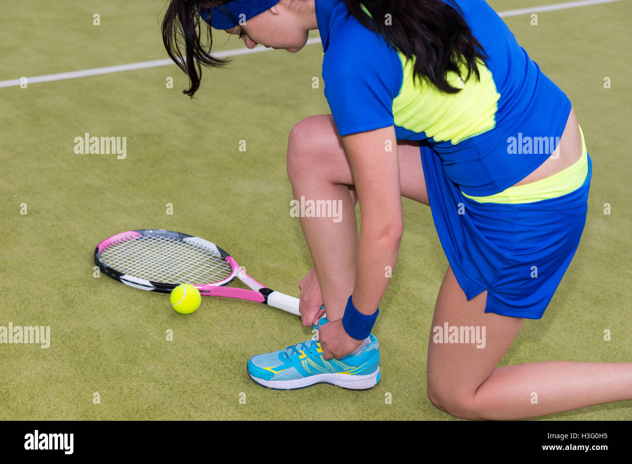 Beautiful female tennis player tying shoelaces wearing a sportswear ...