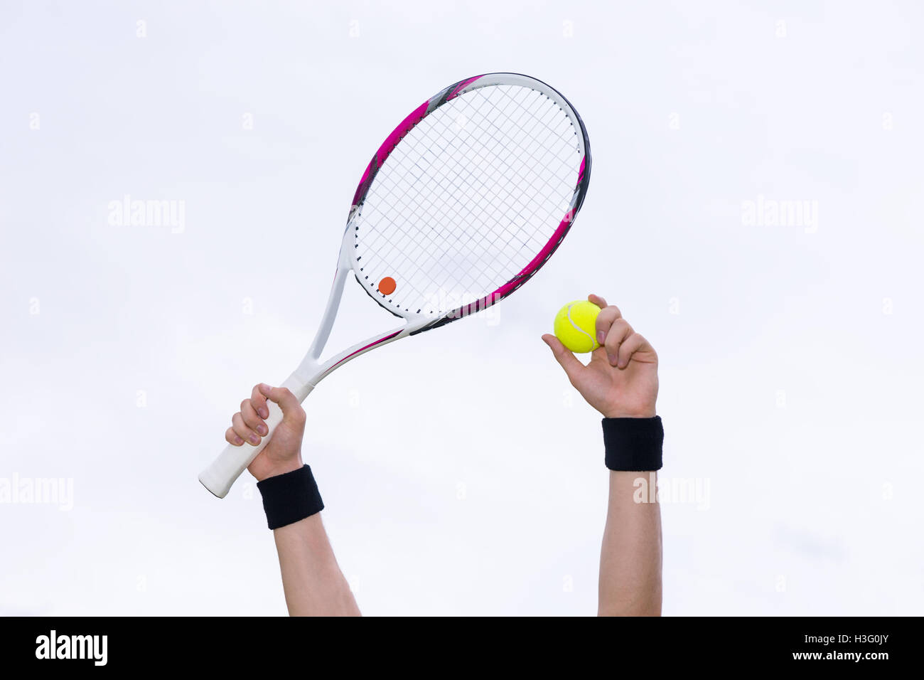 Human hands with wristbands holding tennis ball and a racket on ...