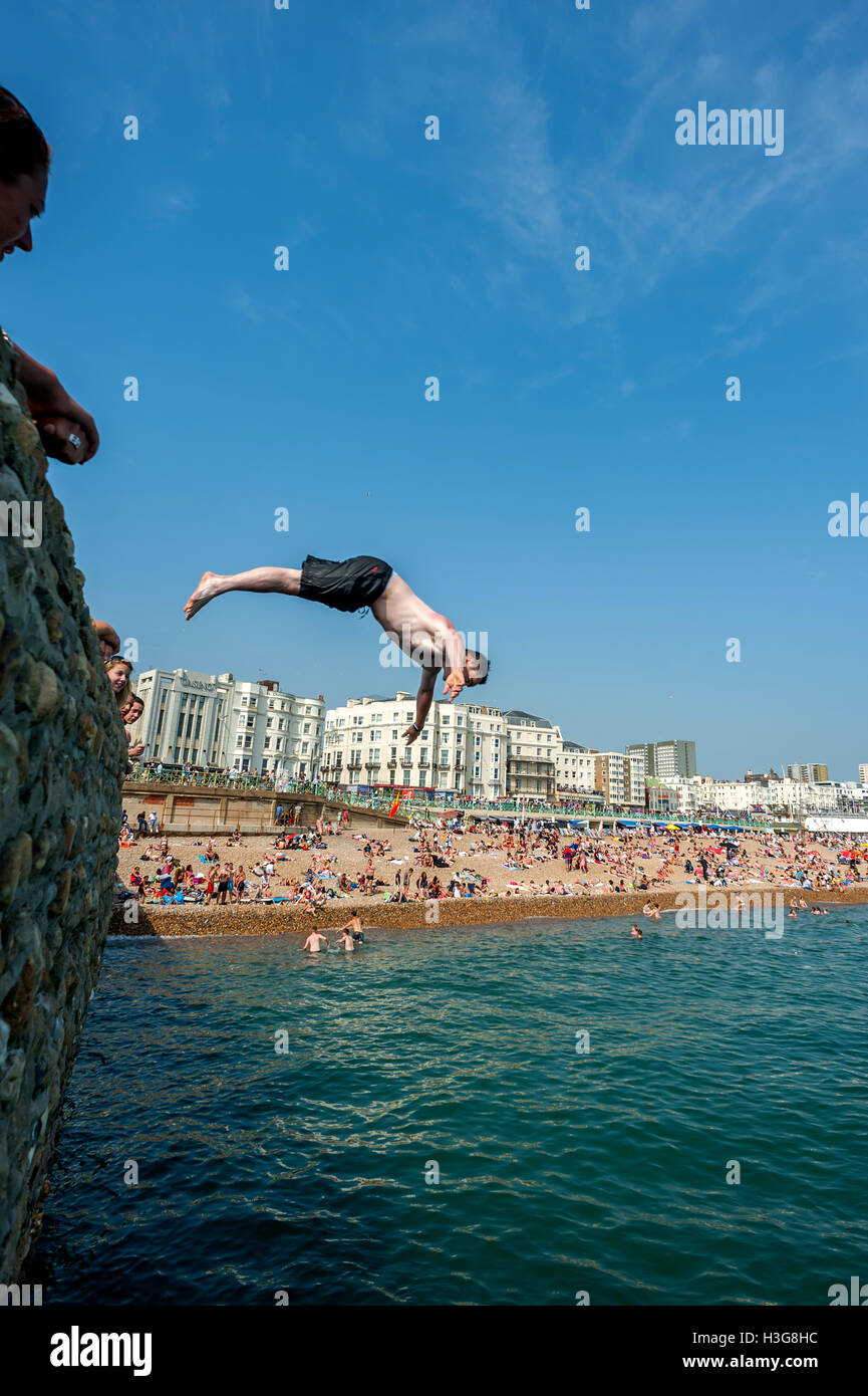 Young men jumping into the sea from the Banjo Groyne on Brighton ...