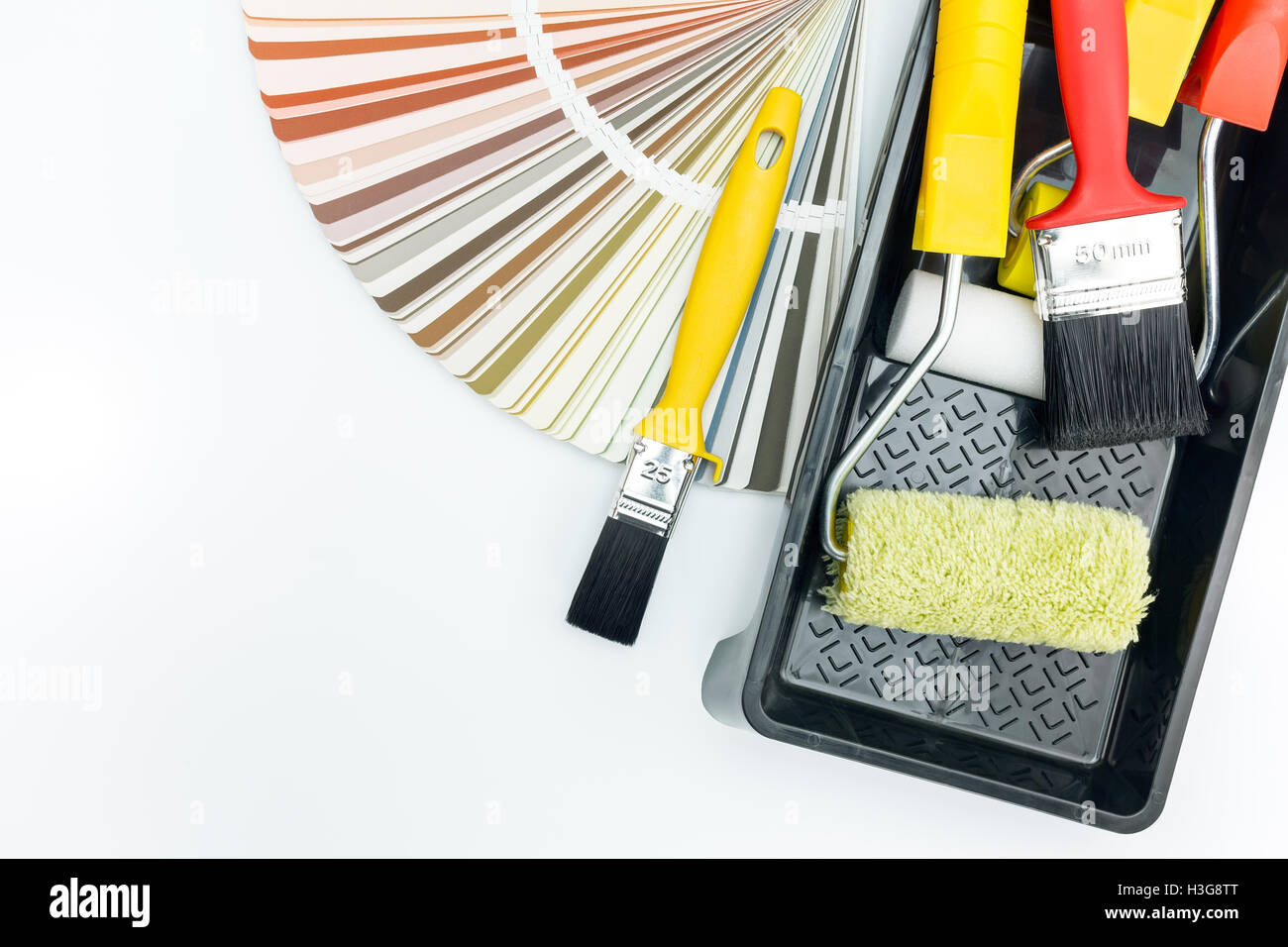different paintbrush and rollers in tray with color guide Stock Photo ...