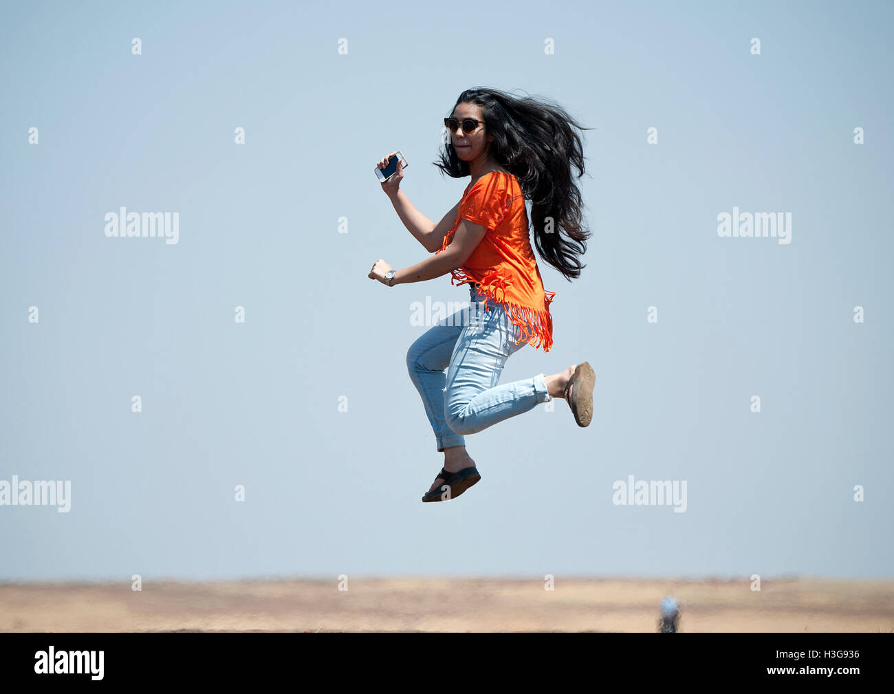 The image of Excited teenage girl jumping up in the air, India Stock ...