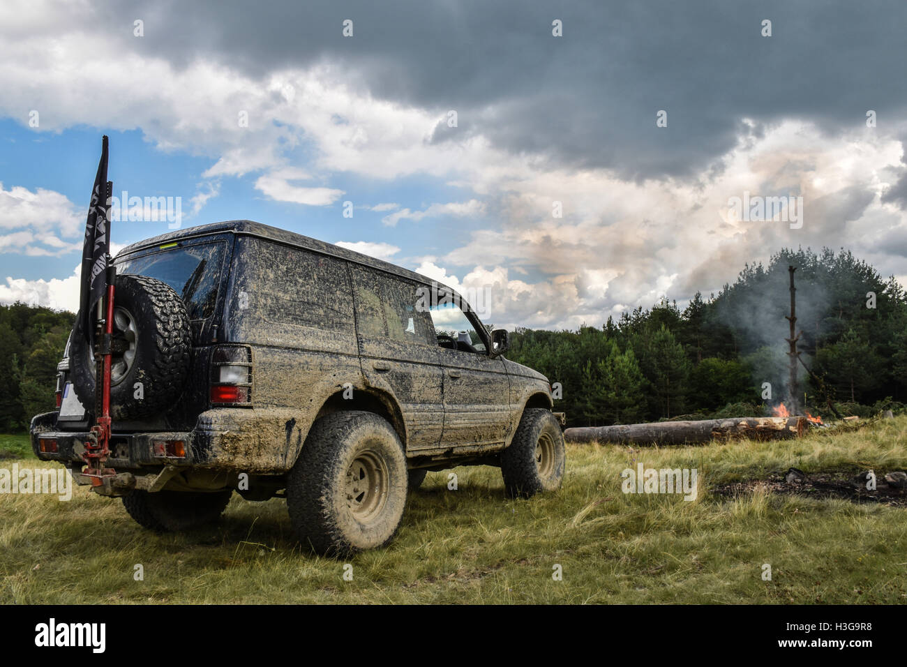 A dirty 4x4 offroad SUV parked before a campfire Stock Photo - Alamy