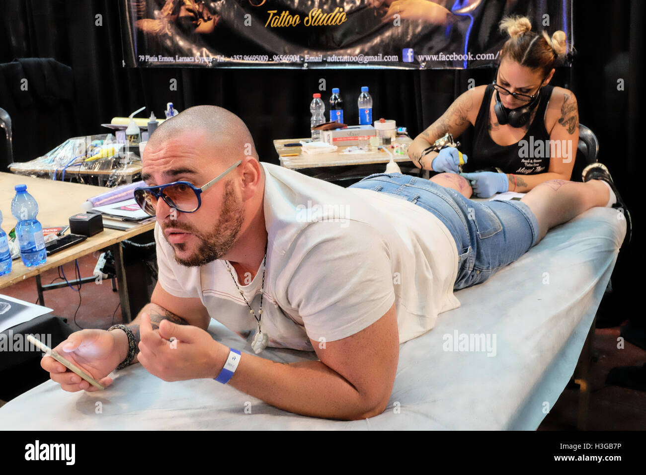 Tel Aviv, Israel. 7th October, 2016. A tattoo artist tattoos the back ...