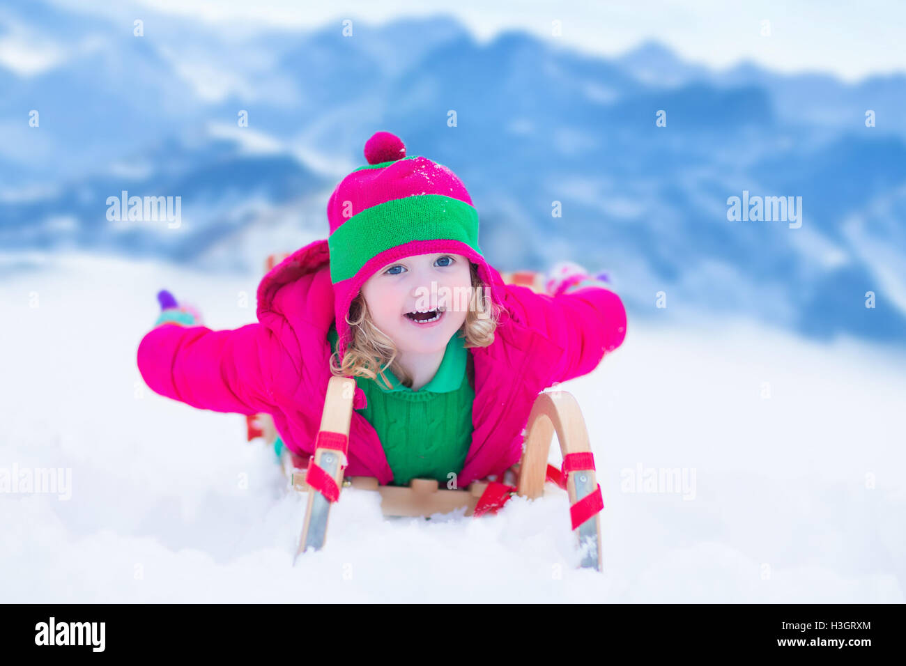 Little girl enjoying a sleigh ride. Child sledding. Toddler kid riding ...