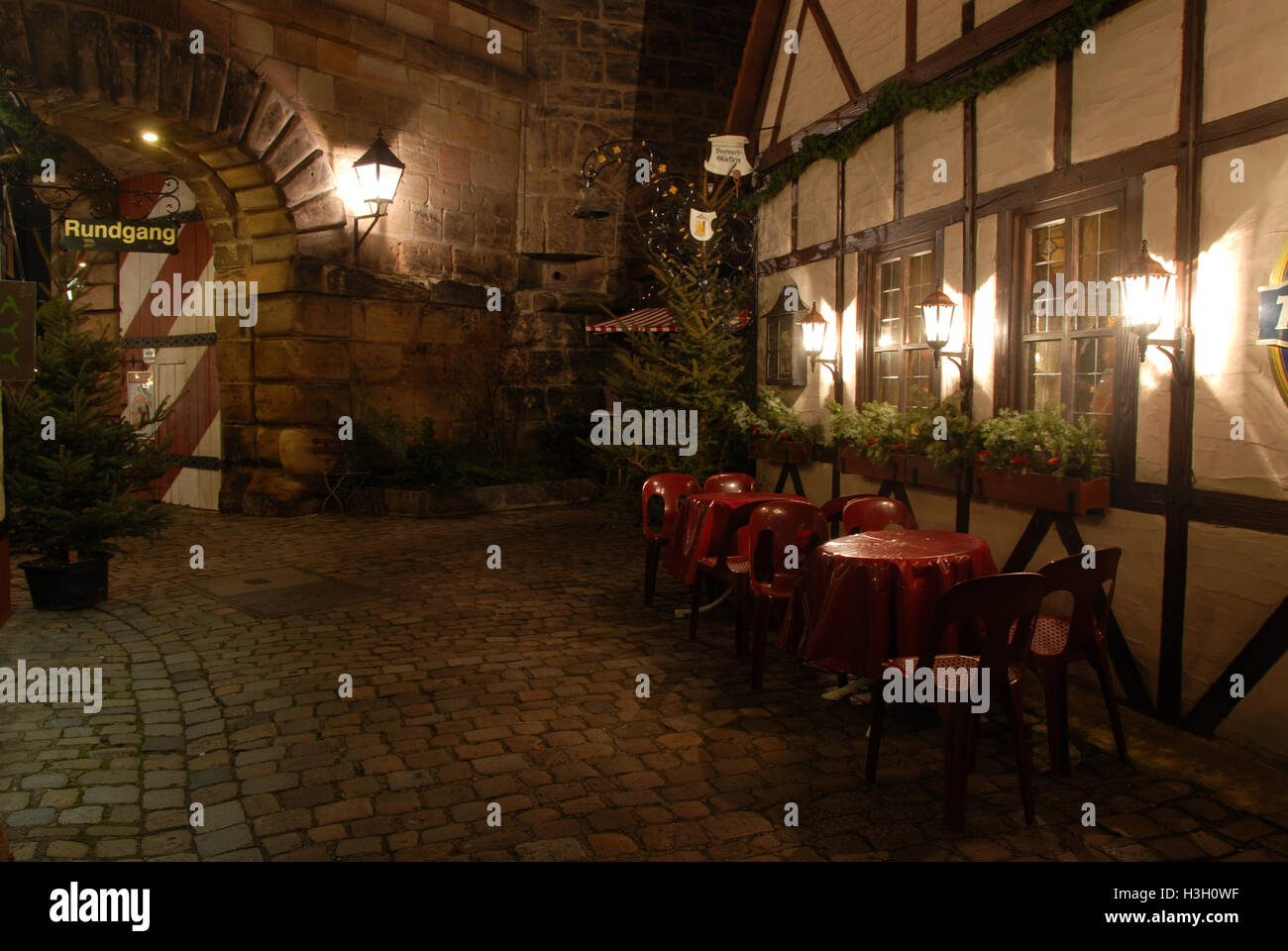 Under dimly-lit lights Empty chairs and tables outside a restaurant in ...