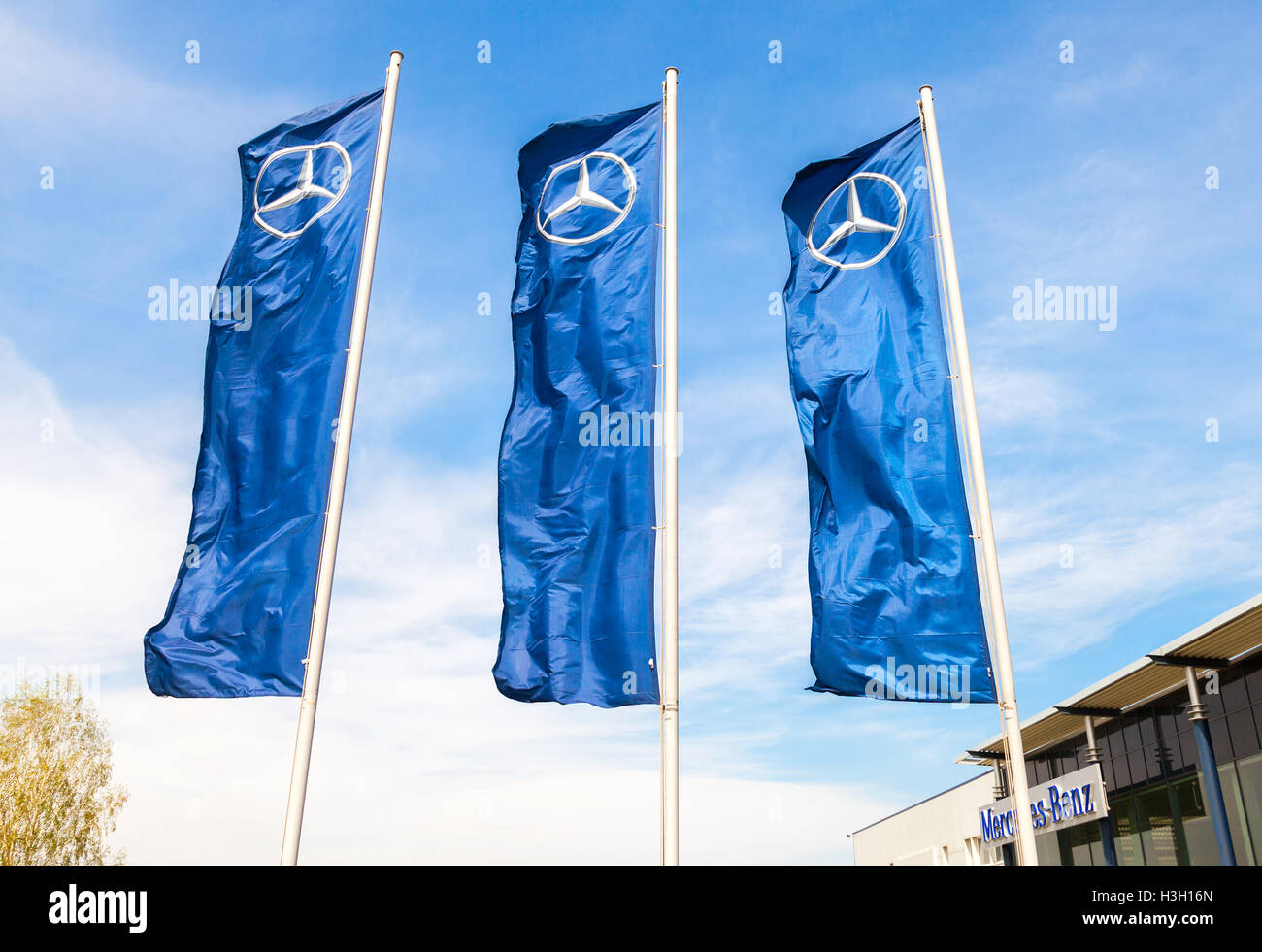 Dealership flags of Mercedes-Benz over blue sky near the office of ...