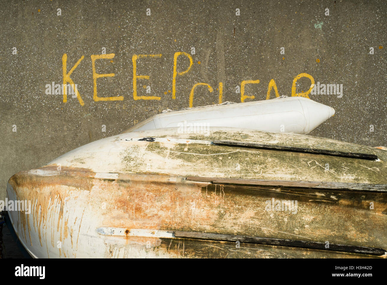 A Keep Clear sign partially covered by an abandoned sailing boat in ...