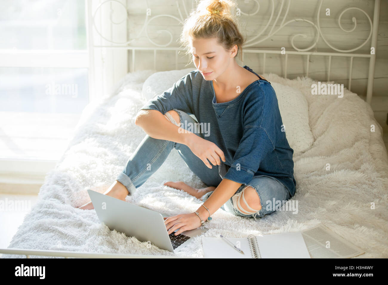 Attractive woman sitting on bed Stock Photo - Alamy