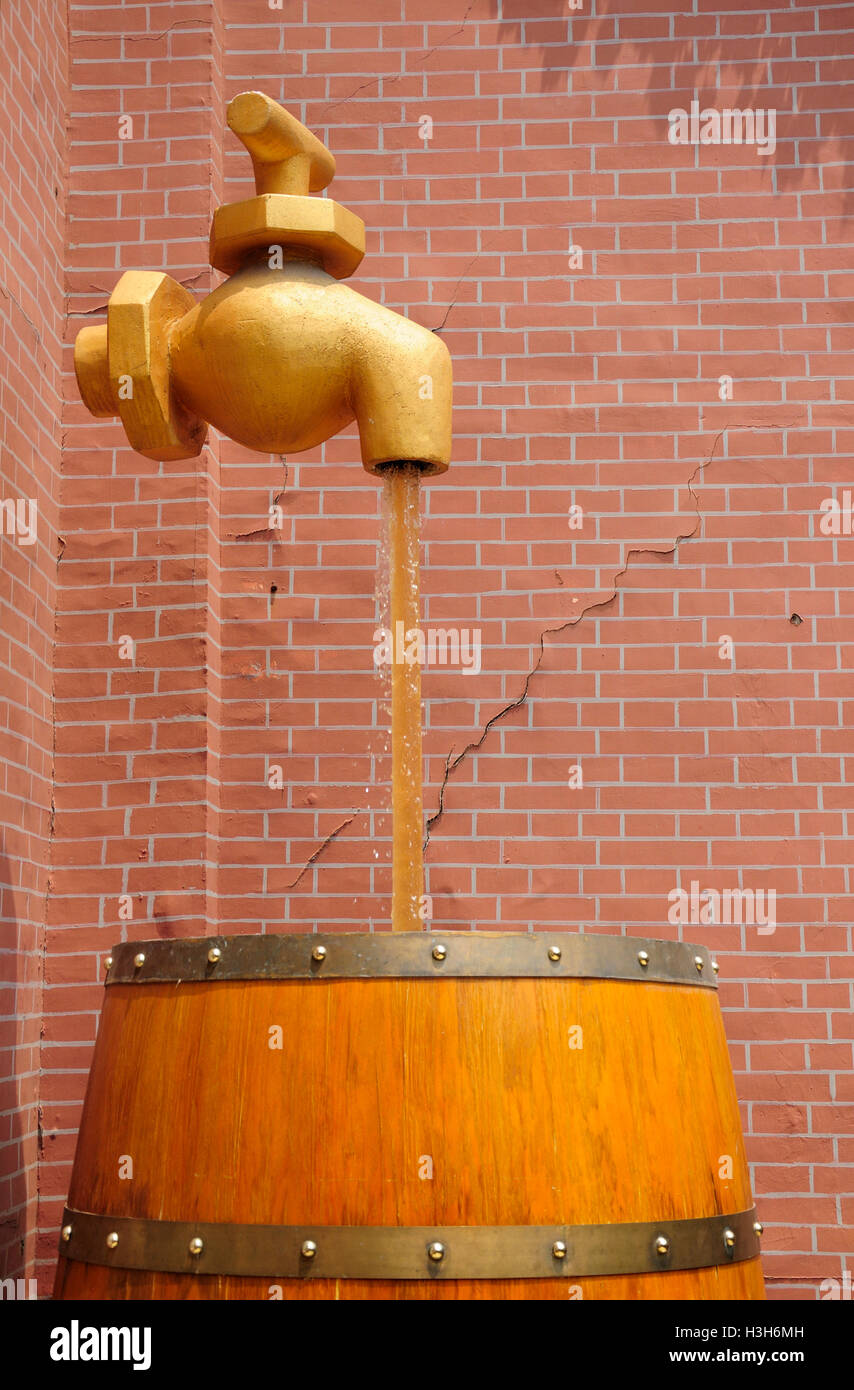 An optical illusion of a large brass faucet with beer flowing from it ...