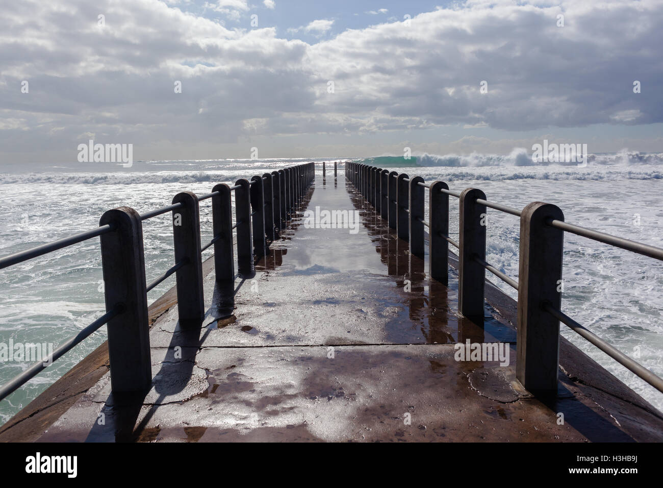 Beach pier jetty with ocean storm waves crashing with water power Stock ...