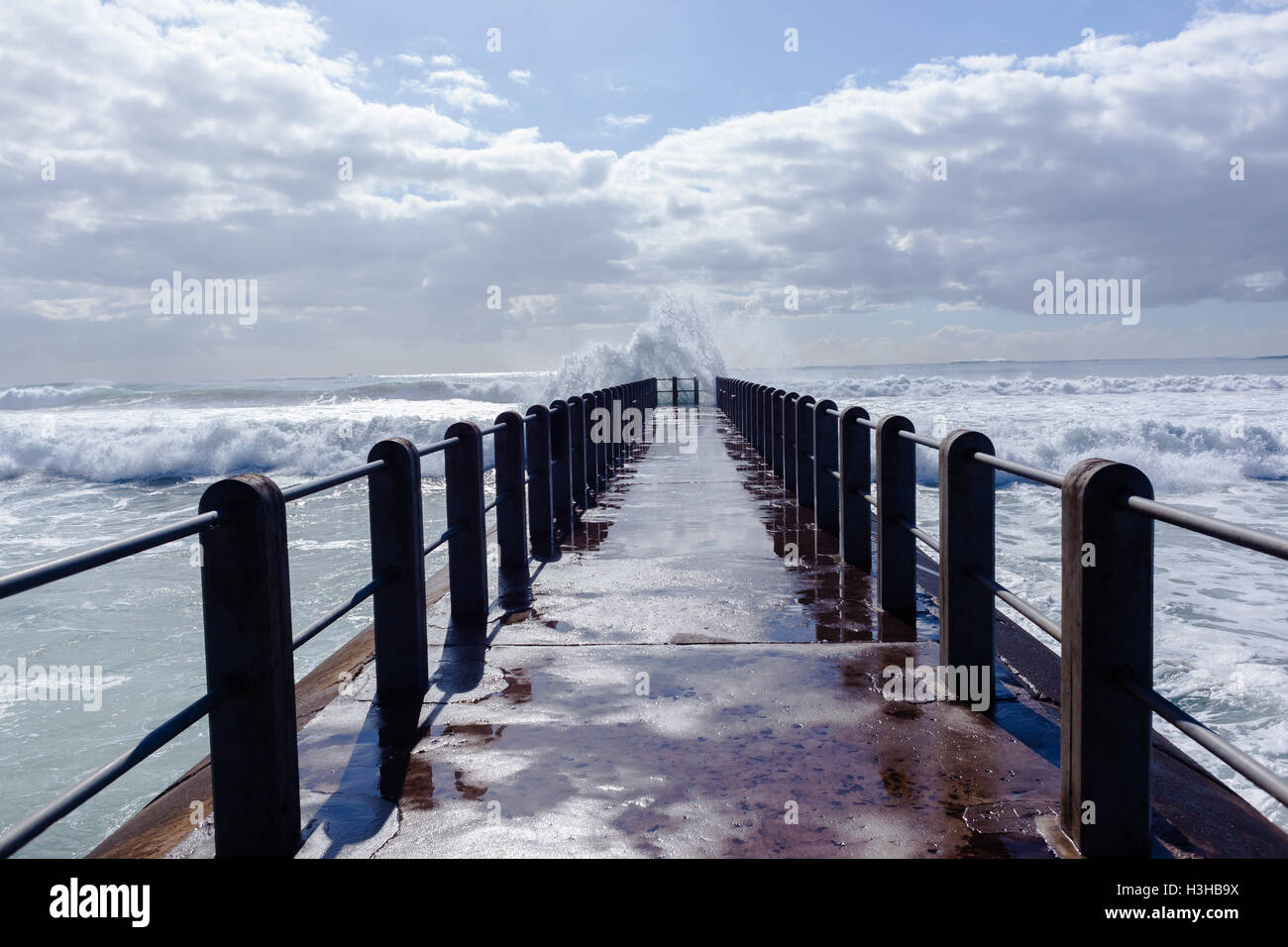 Beach pier jetty with ocean storm waves crashing with water power Stock ...