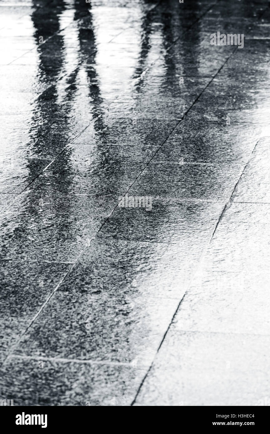 wet street pavement with raindrops rippling in puddles during bad ...