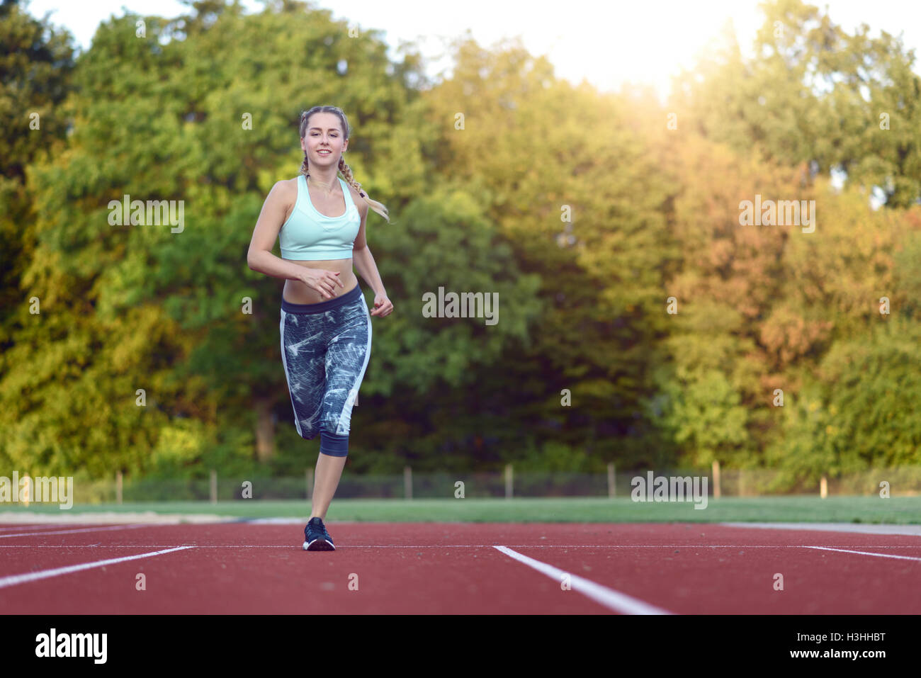 Female athlete training for a race as she practices her start for a ...