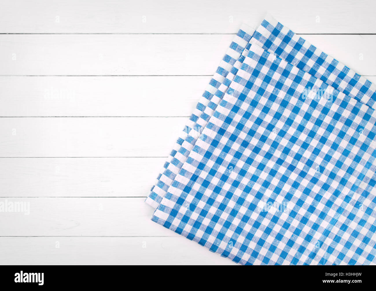 Blue checkered folded tablecloth on white wooden table, top view Stock ...