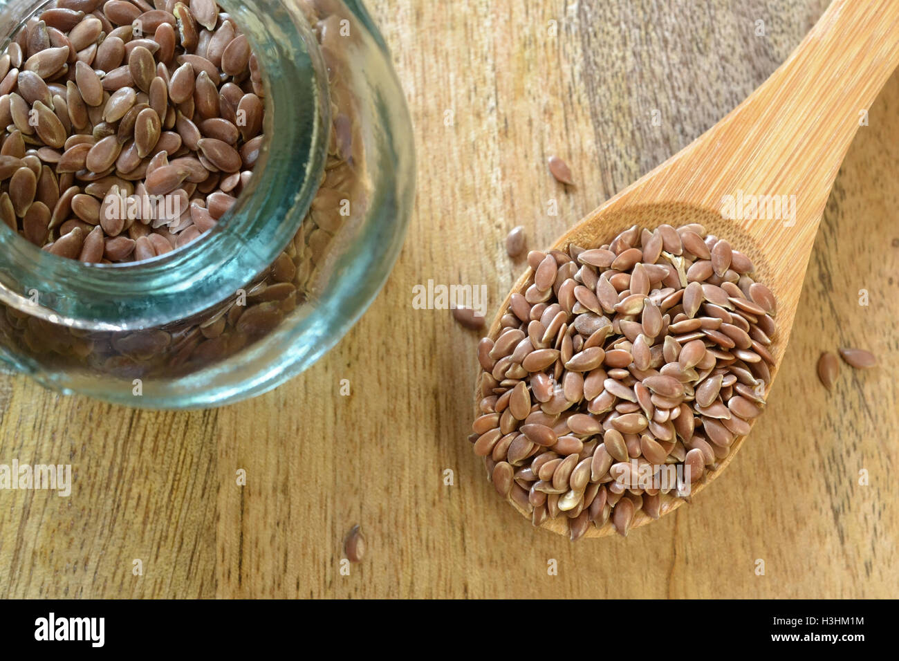 Flax seeds in glass container and in wooden spoon on wooden table Stock ...