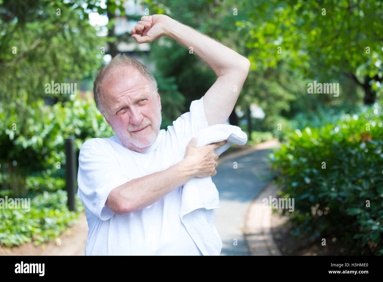 Closeup portrait, old gentleman in white shirt wiping sweat droplets ...